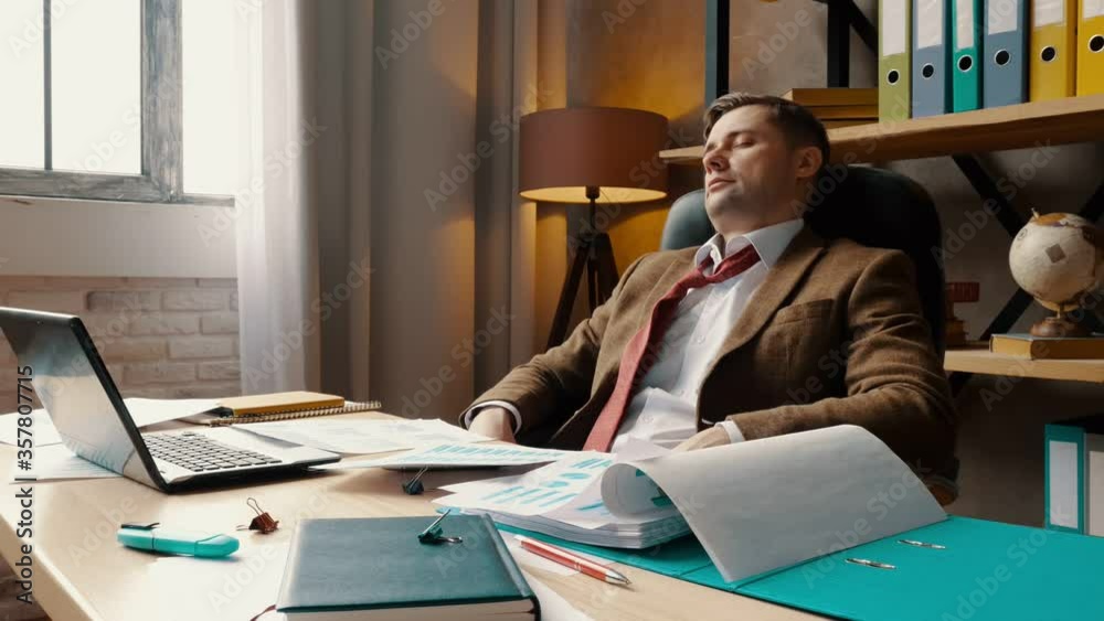 Tired, overworked businessman relaxes while sitting on the chair ...