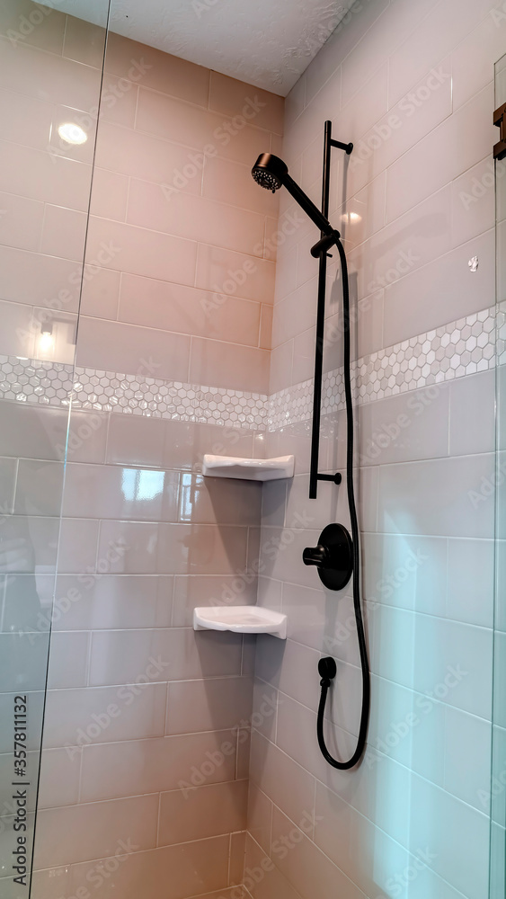Vertical frame Black round shower head on tile wall of shower stall ...