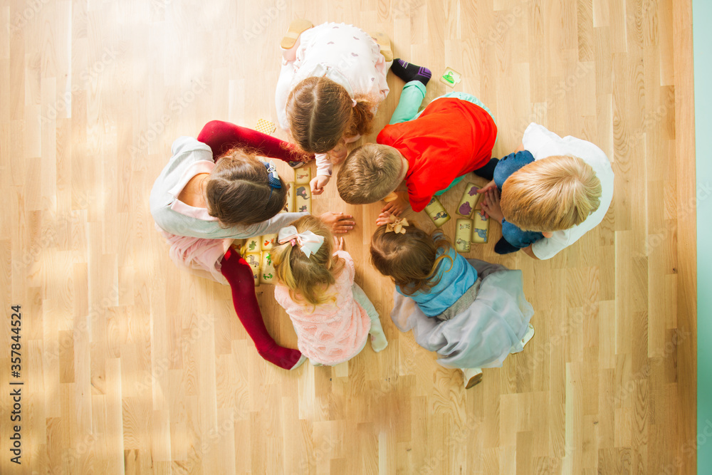 Group of children playing educational cards on a floor. Puzzle with ...