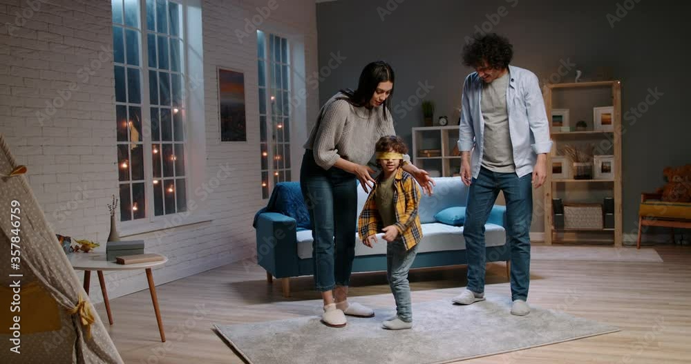 Asian parents playing active games with their child with curly hair at ...