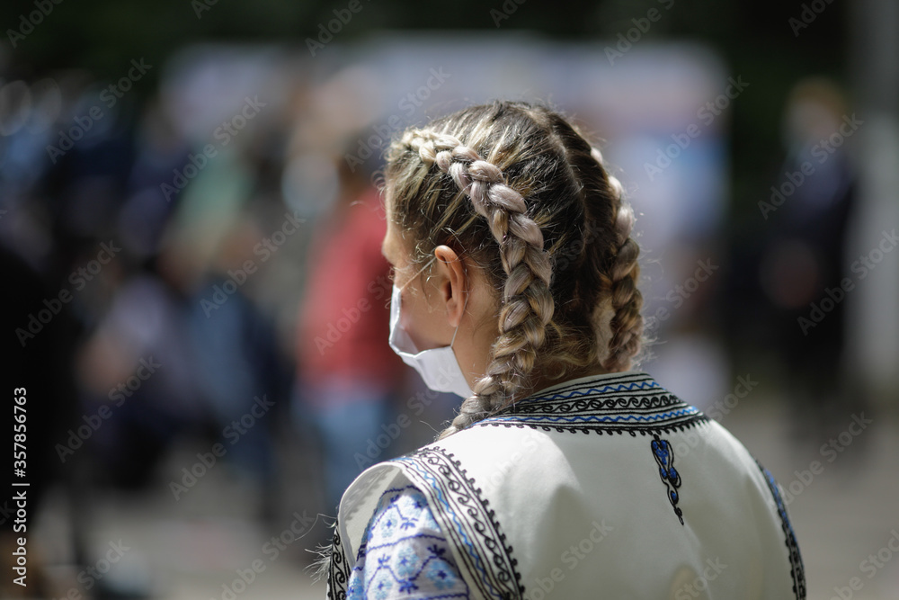 Details with the braids of a blonde woman dressed in Romanian ...