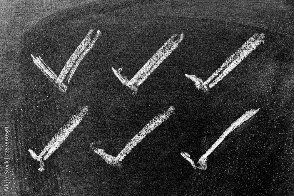 White color chalk hand drawing in set of check mark shape on black ...