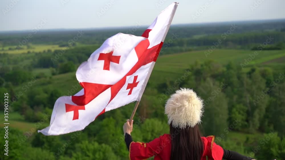 Georgian girl with national flag of Georgia in hands walks around green ...