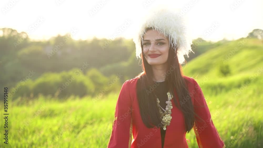 Georgian girl in white papakha and red national dress walks and smiles ...