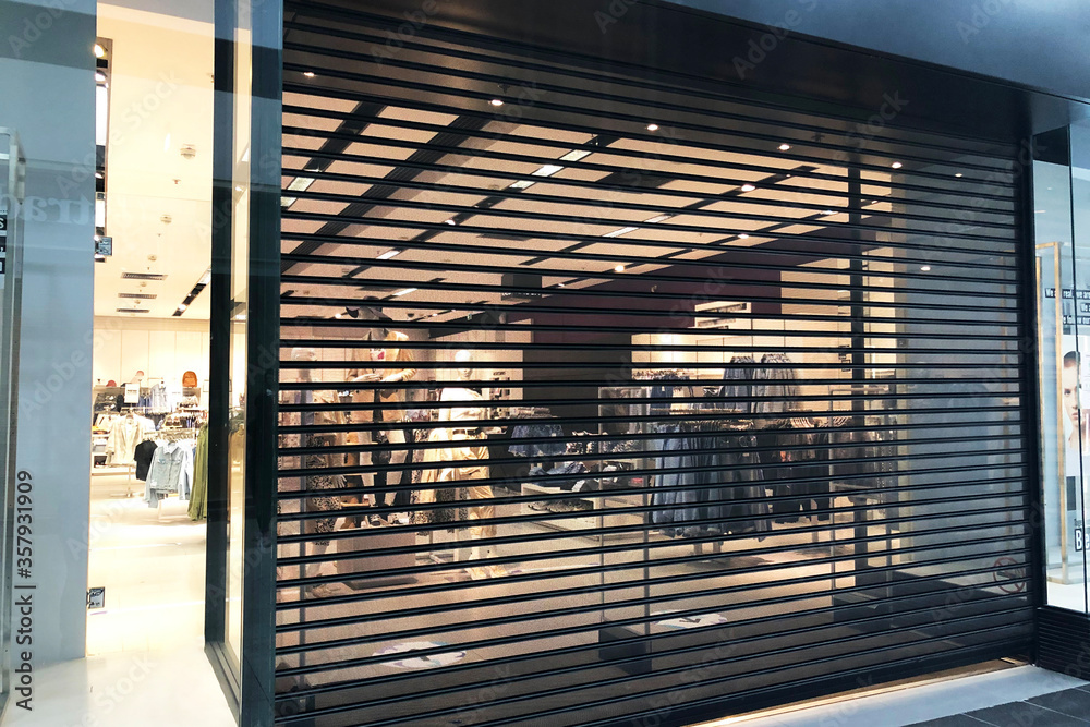 black shutted iron gates of shop in shopping mall due to restrictions ...