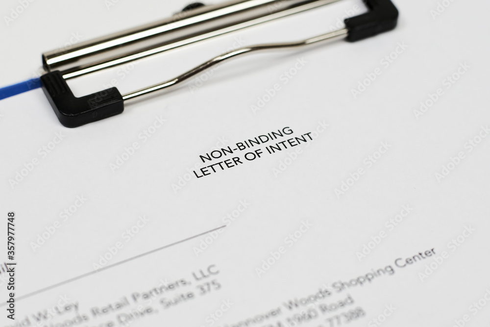 An unrecognizable person filling non-binding letter of intent. Close-up ...