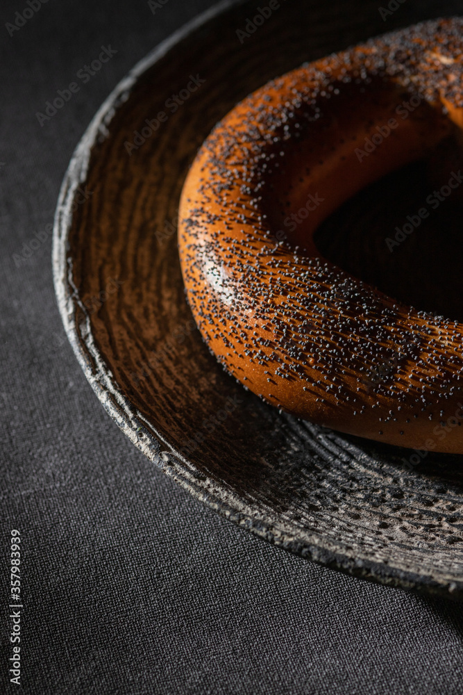Ring shaped roll | Bagel with poppies on the top served in the dark ...