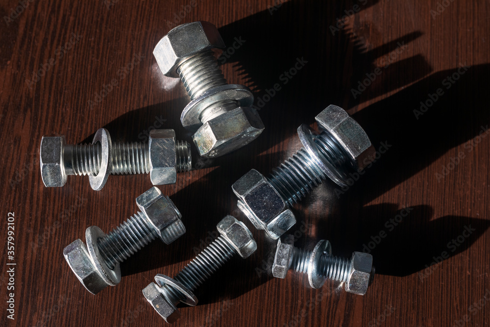 A lot of bolts and nuts on the table. A bolt is a form of threaded ...