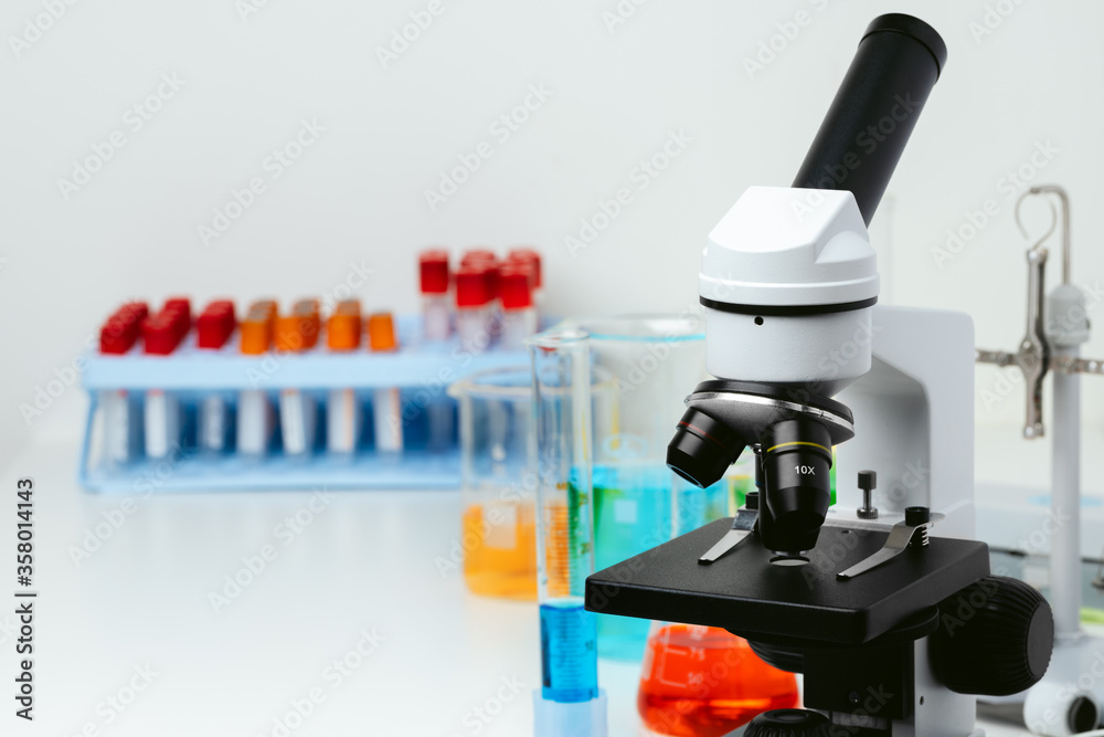 Microscope and test tubes on table in laboratory, close up Stock Photo ...