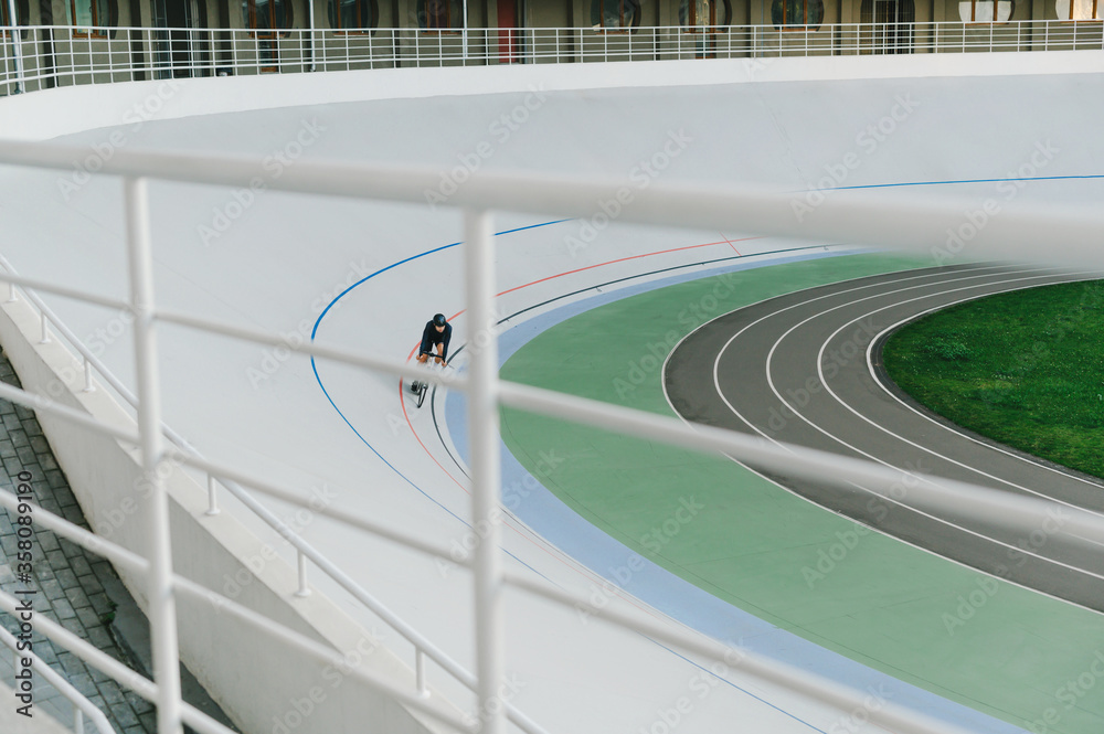 Cyclist in cycling gear trains on a track bike at the velodrome ...
