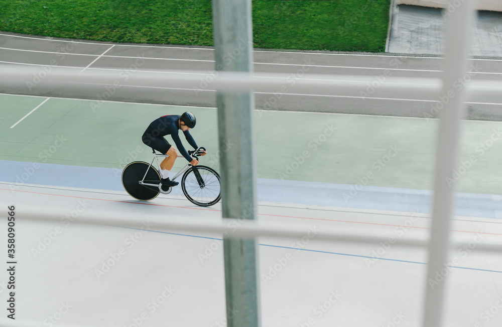 Professional cyclist in sports equipment trains on an empty velodrome ...