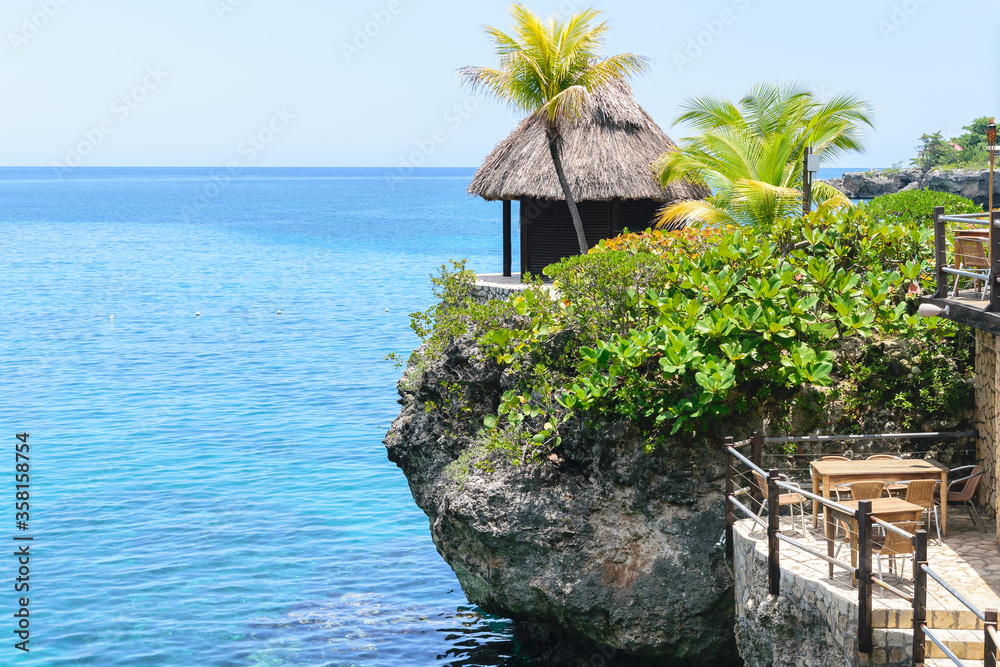 Outdoor restaurant with thatch roof hut on coastal cliffs in Negril ...