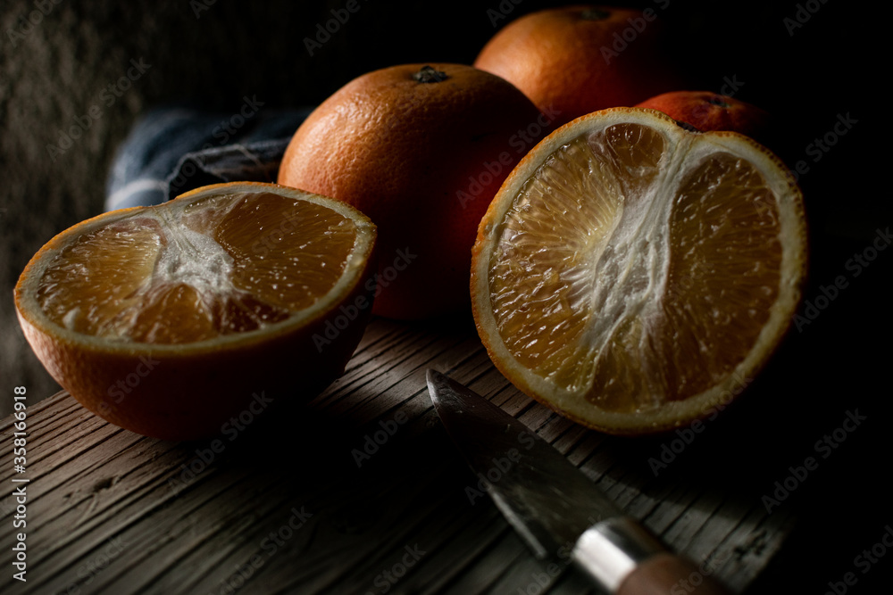 naranjas cortadas con cuchillo por la mitad, sobre un fondo claro y ...