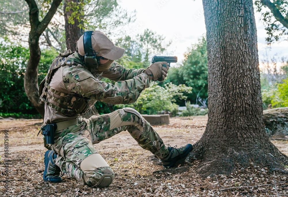 Soldier pointing his gun. USP gun. Airsoft player. Multicam camouflage ...