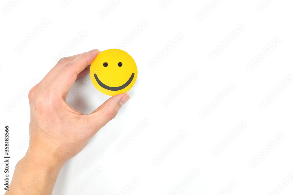 Happiness and positivity concept. Hand holding yellow smiling face in ...