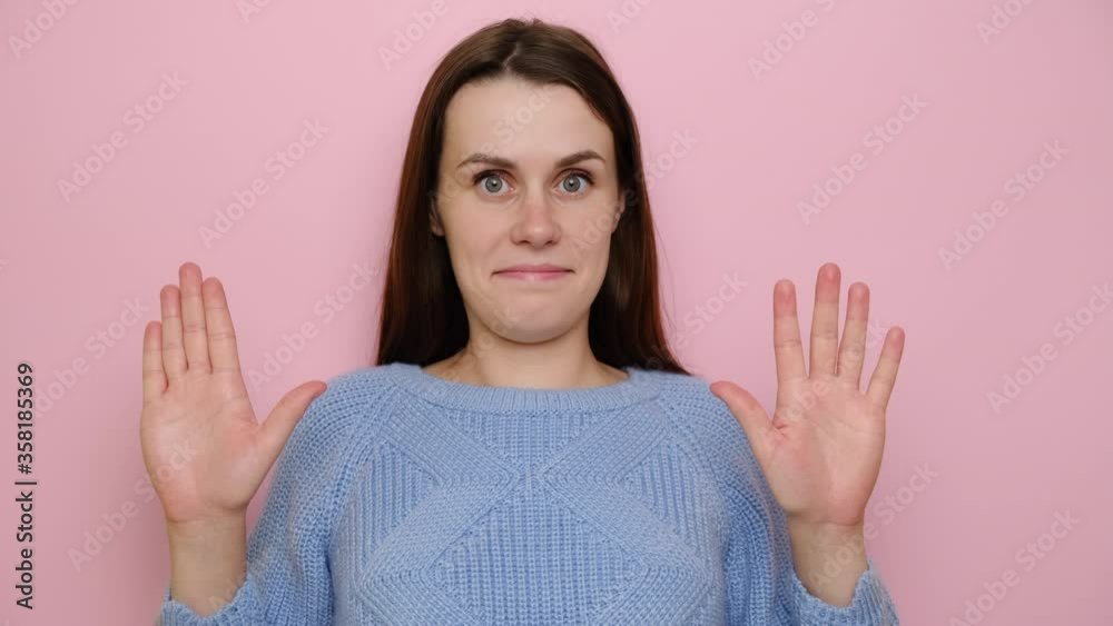 Confused brunette woman isolated on pink background raises palms, shows ...