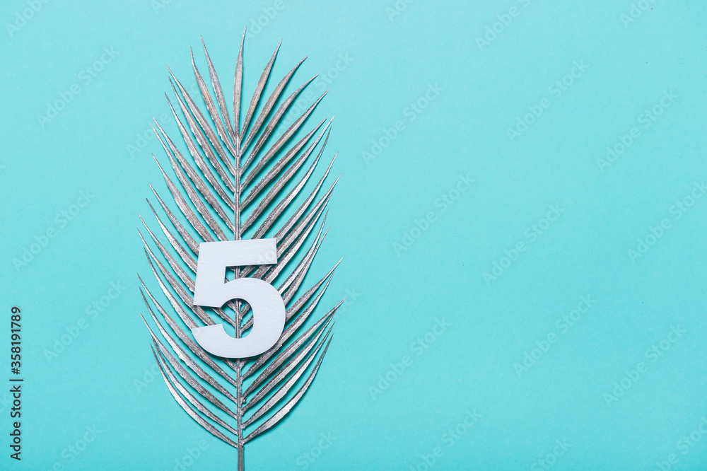 Number five shape with silver palm leaves on blue background. Summer ...