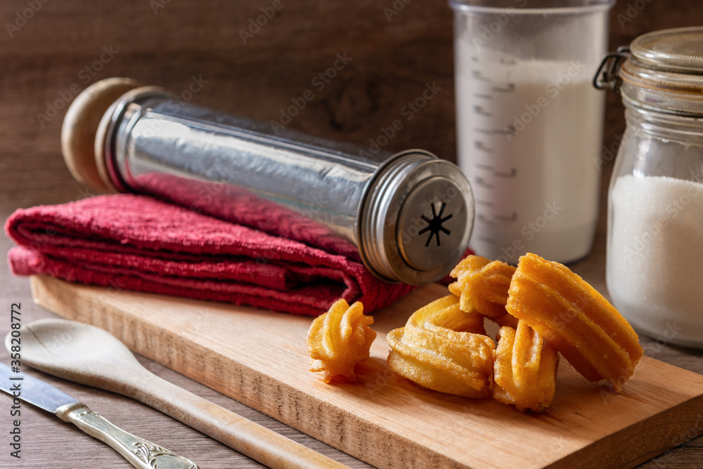 Churrera y antigua con churros caseros sobre tabla de madera Stock ...
