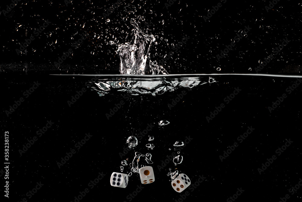 Ludo dice in water splash on black background with lots of air bubbles ...