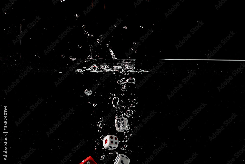 Ludo dice in water splash on black background with lots of air bubbles ...