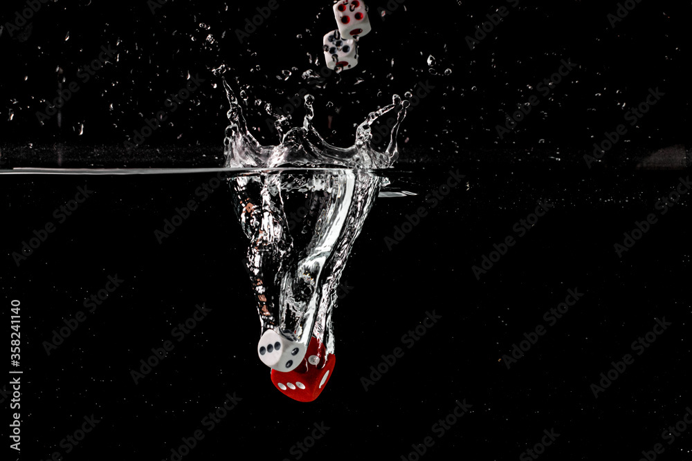 Ludo dice in water splash on black background with lots of air bubbles ...