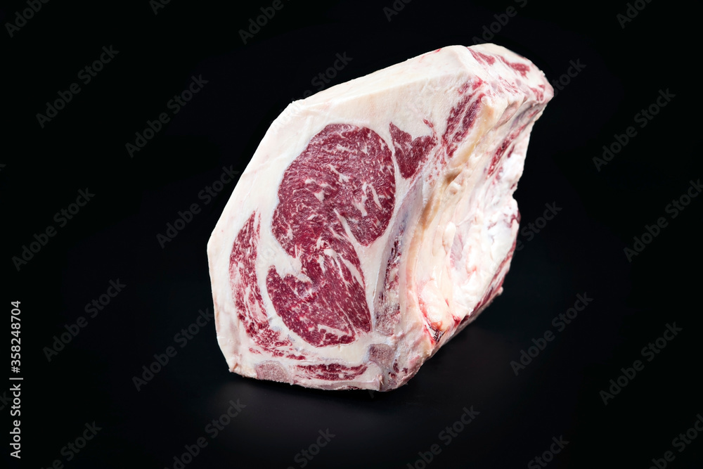 Raw dry aged wagyu cote de boeuf beef block as closeup on black ...