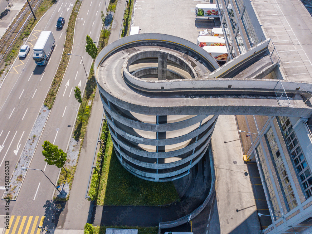 Aerial view of rooftop parking ramp. Spiral ramp leading cars to ...