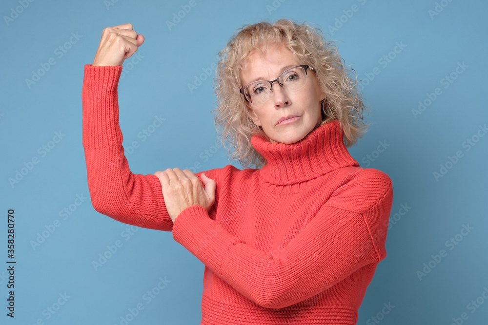 Strong powerful mother raises arms and shows biceps. Woman power ...