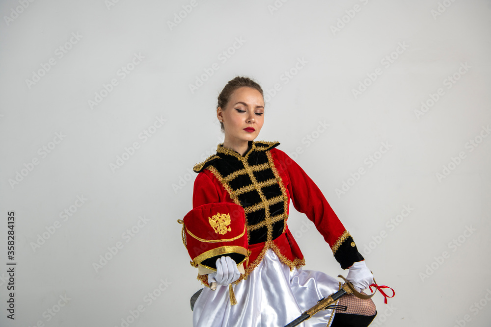 beautiful girl in a red antique hussar costume posing on a white ...