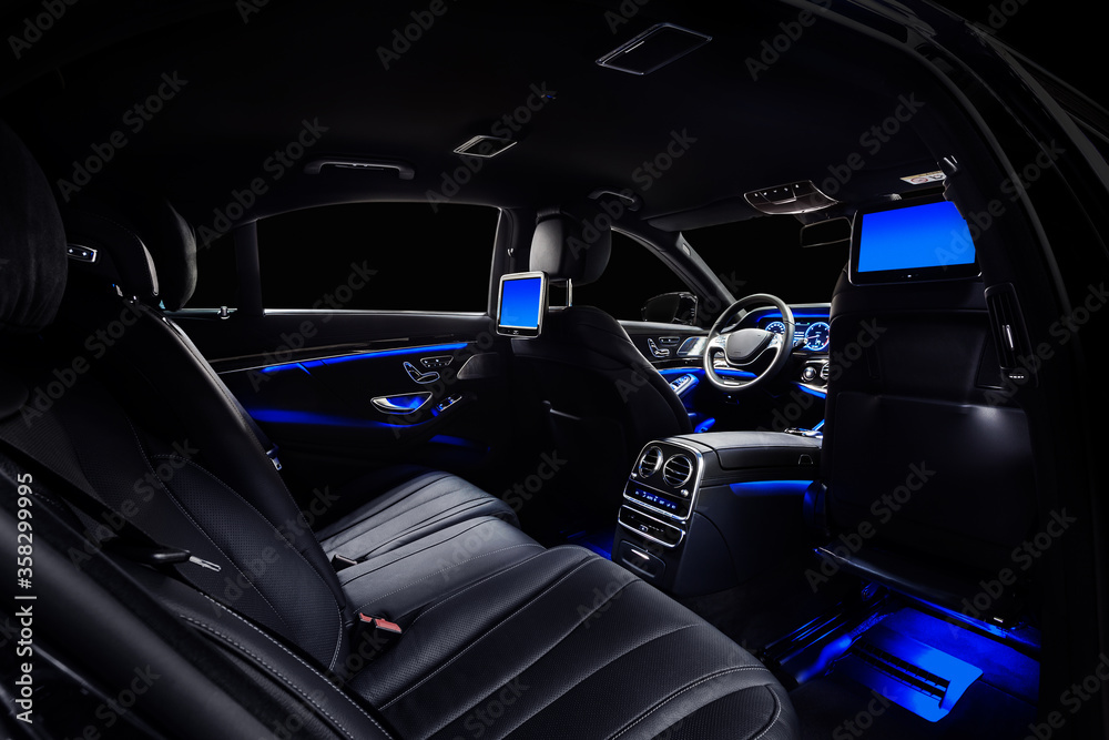 Car interior with comfortable black leather seats, displays and blue ...