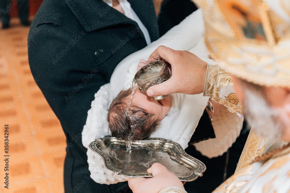 Newborn baby baptism in Holy water. Baby holding mother's hands ...