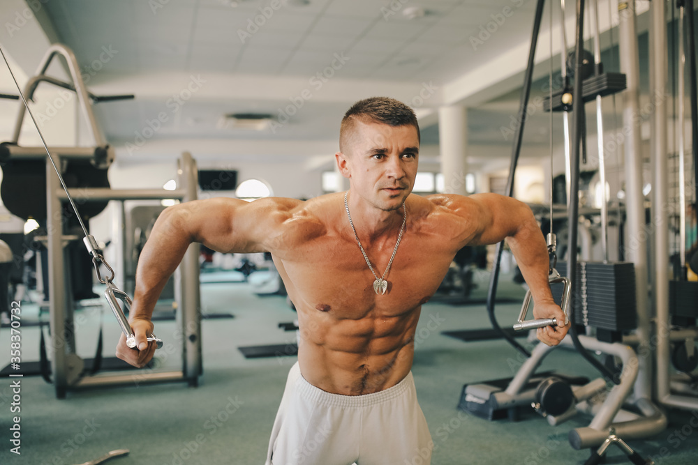 Young handsome sportsman bodybuilder weightlifter with an ideal body ...