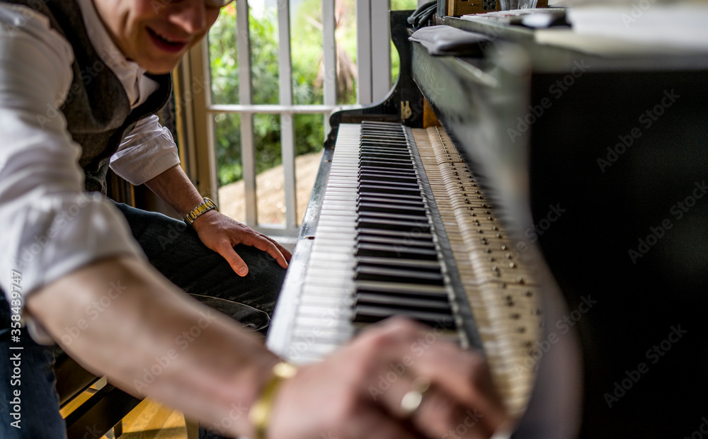 Man leaning towards camera to touch the keys of a Grand PIano, Arms ...