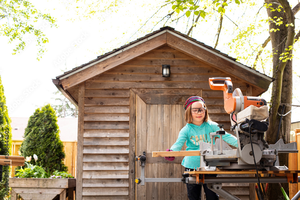 Young girl using table saw Stock Photo | Adobe Stock