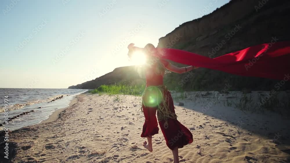 Oriental girl in a burqa and in a red caftan with belly dancing on the ...