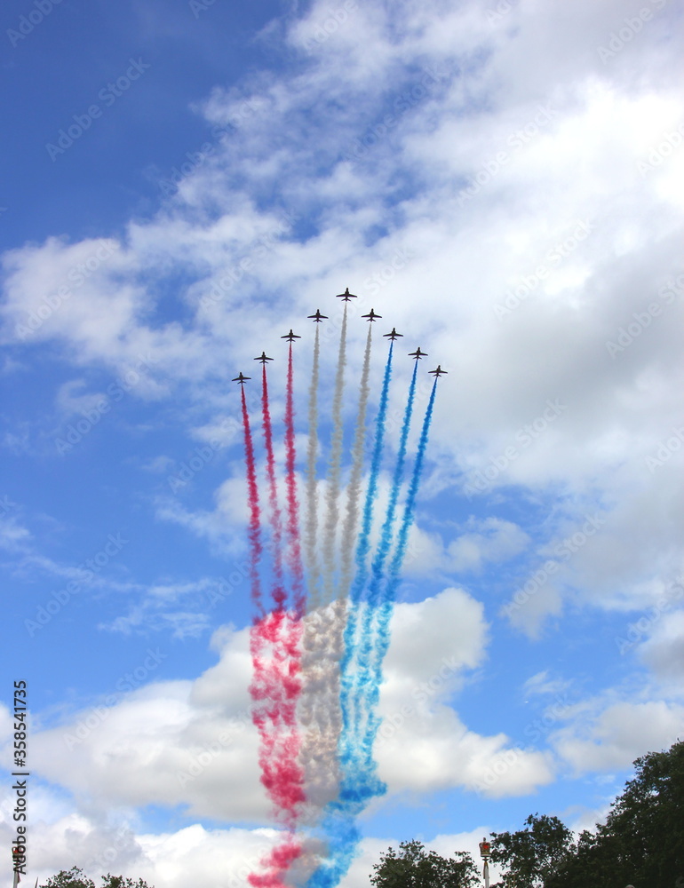 Red Arrow jet planes flying with red, white and blue smoke trails Stock ...