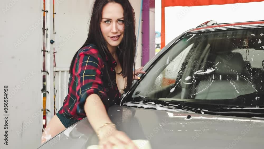 Hot girl in bodysuit and plaid shirt sexually washes the hood of ...