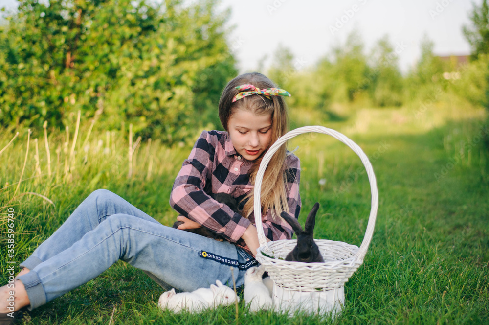beautiful girl with a rabbit. girl laughs and kisses a rabbit. card ...