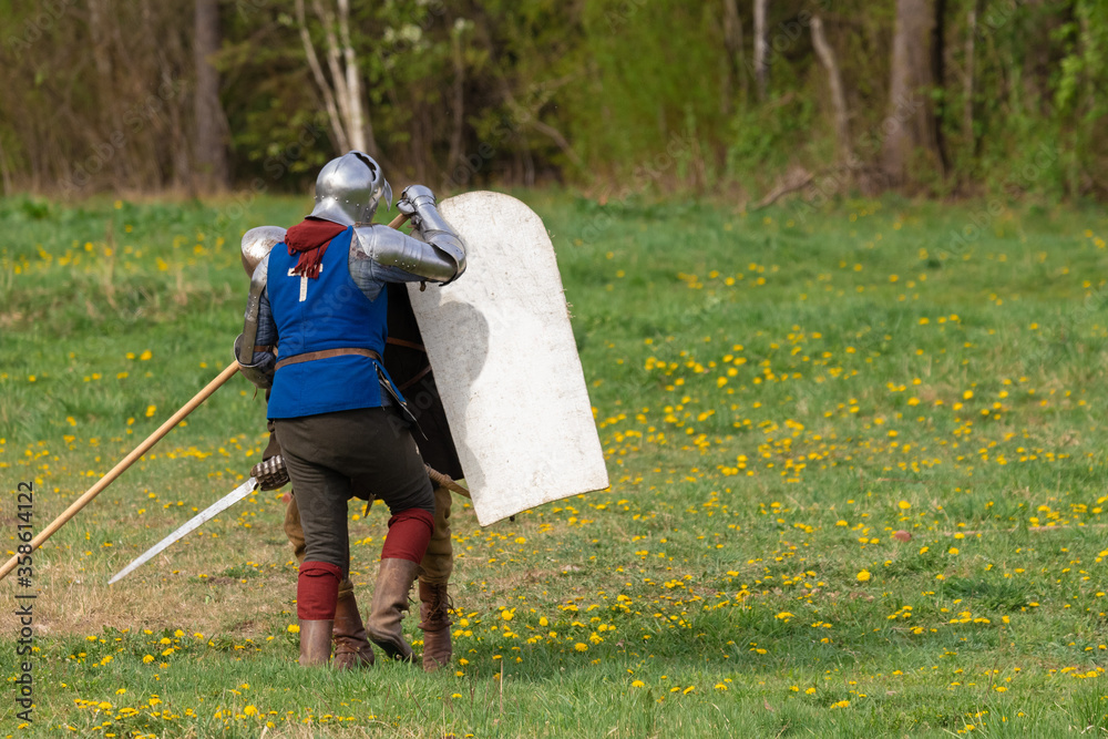 Knights in armor fight on the battlefield. Reconstruction of an ancient ...