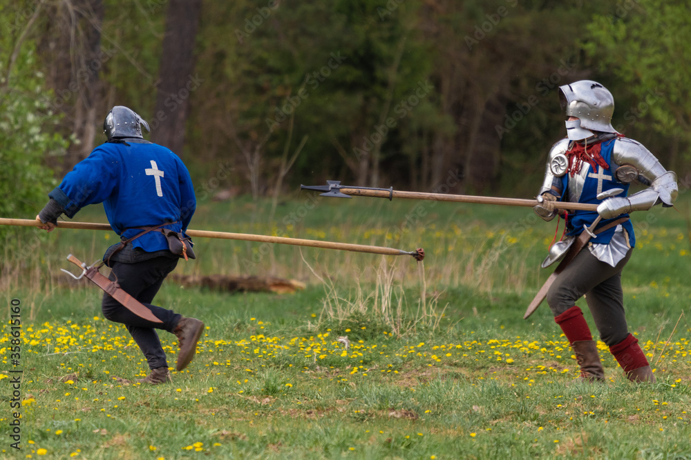 Knights in armor fight on the battlefield. Reconstruction of an ancient ...