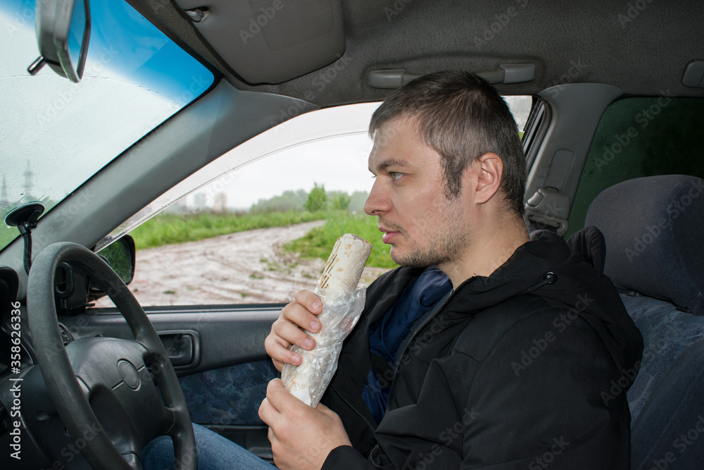Distracted man in vehicle. Bad unhealthy habit. Junk food go. Hungry ...