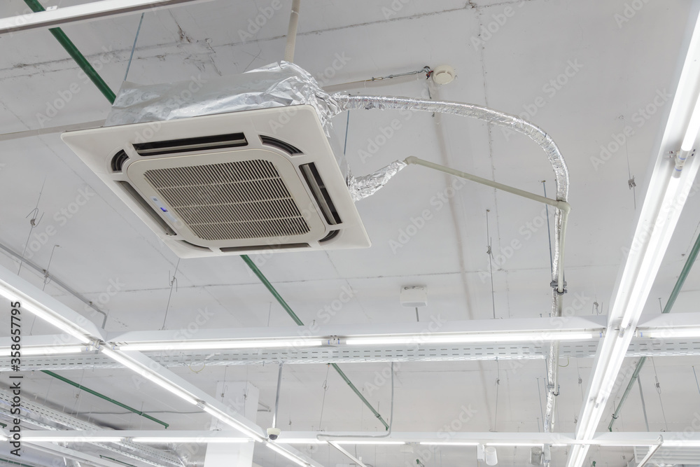 Rectangular ceiling air conditioning appliance. Fan Coil hanging on ...