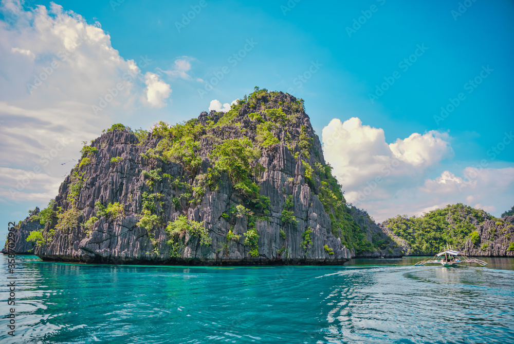 Boat approaching a limestone mountain of Coron, Palawan, Philippines ...