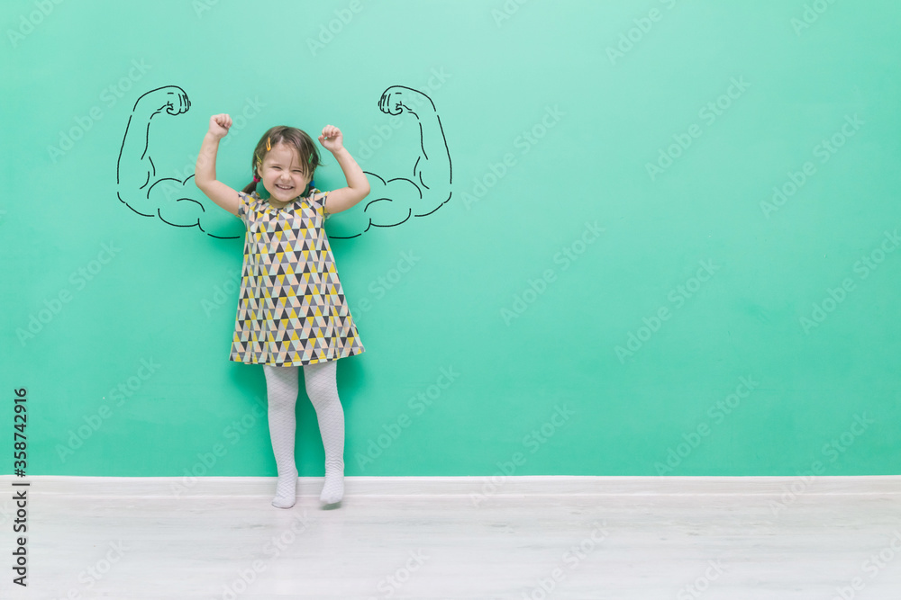 Girl power. The child with hand-drawn muscles in his arms.Funny little ...