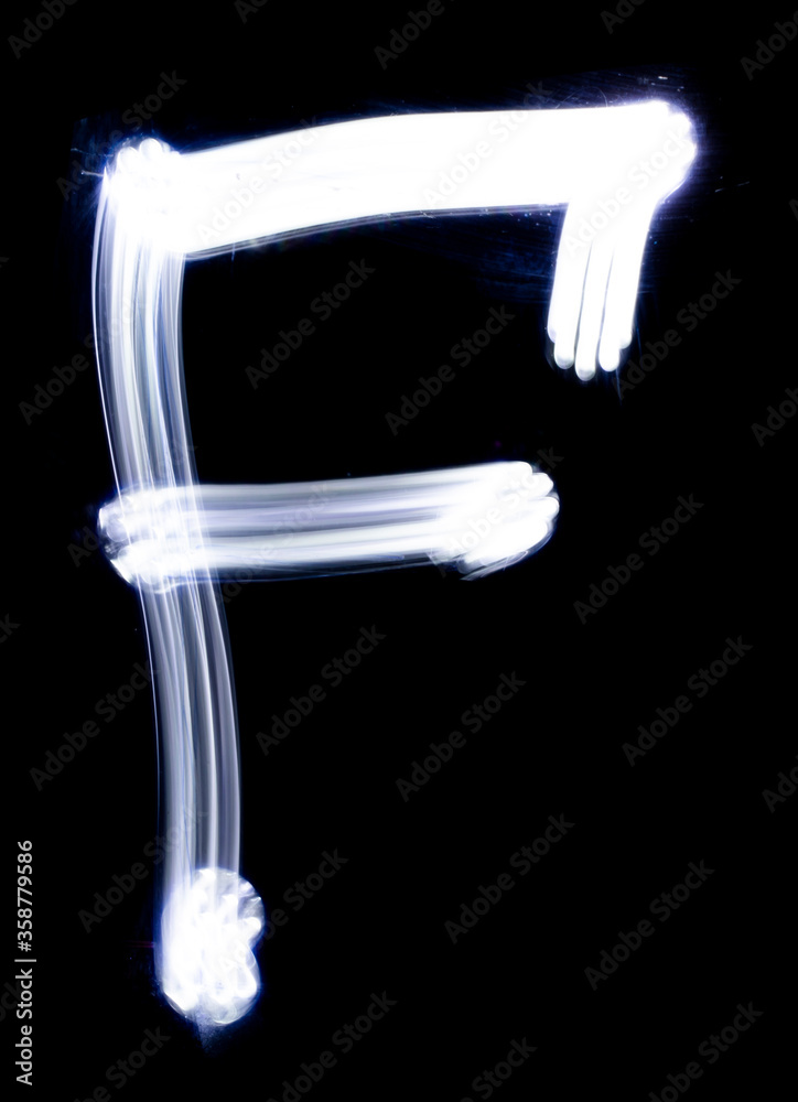 Handwrite letter F, made with light painting technic isolated on black ...