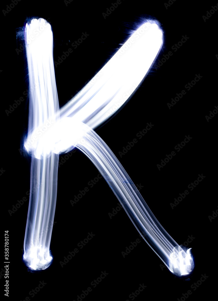 Handwrite letter K, made with light painting technic isolated on black ...