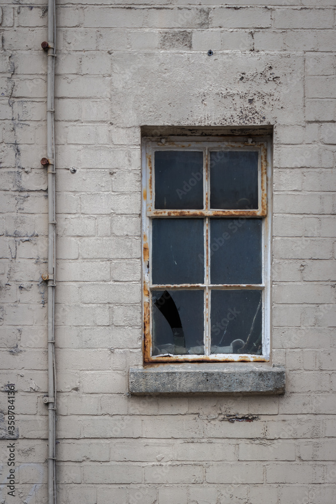Rusted, decaying six pane metal window with cracked, broken glass ...