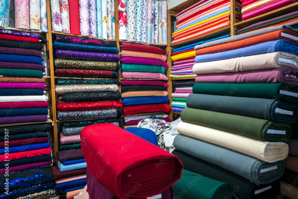 clothes in shop, Rolls of fabric and textiles for sale stacked on ...