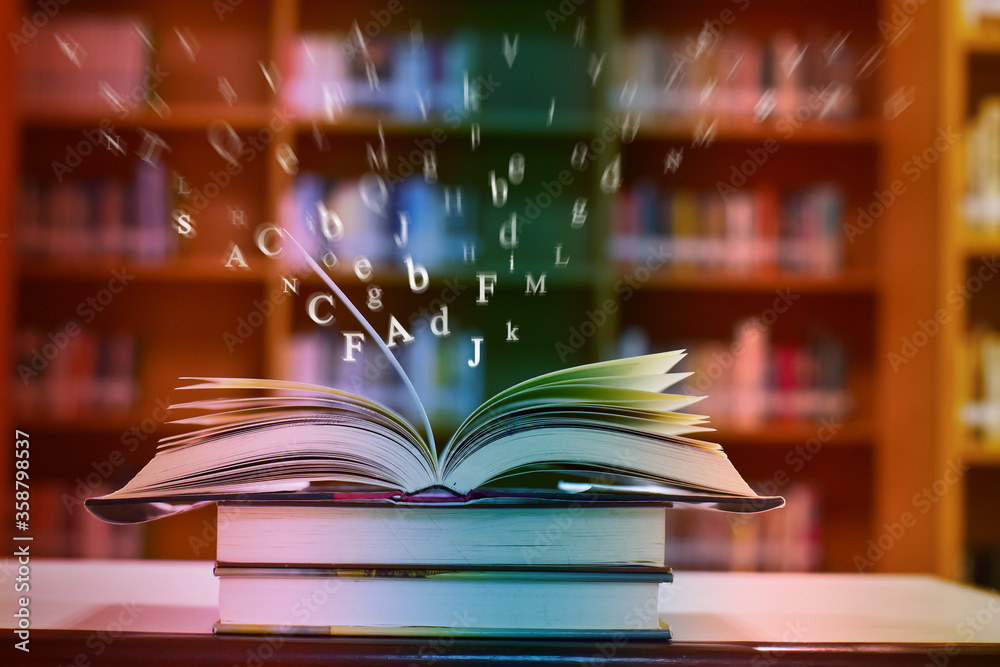 Open book on the table and English alphabet Floating above the book in ...