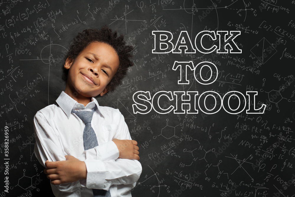Proud black child student on blackboard background. Back to school ...